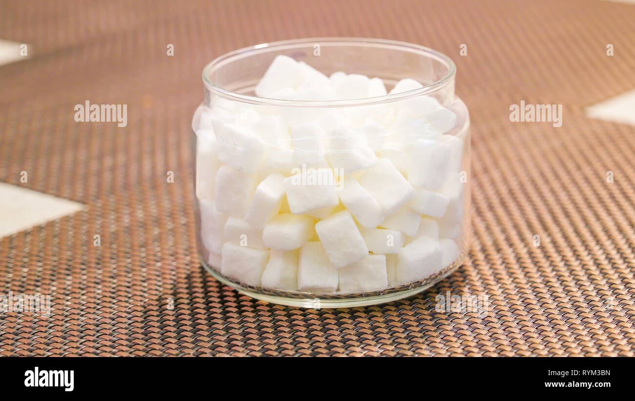 Closer look of the sugar cubes inside the jar on top of the table in ...