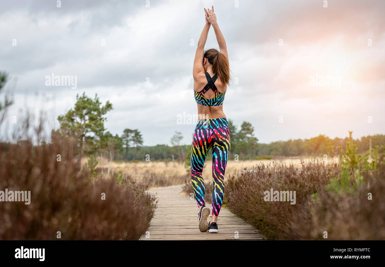 woman doing exercises in the morning sun, back view Stock Photo - Alamy