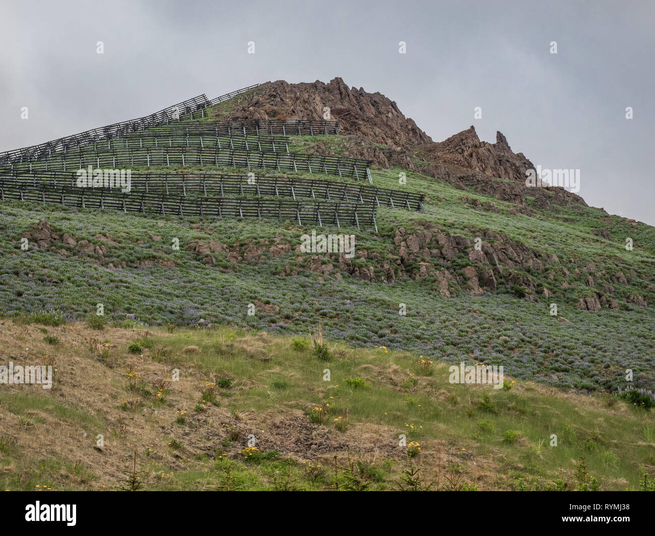 Mountaintop with avalanche protection system barrier on the slope above ...