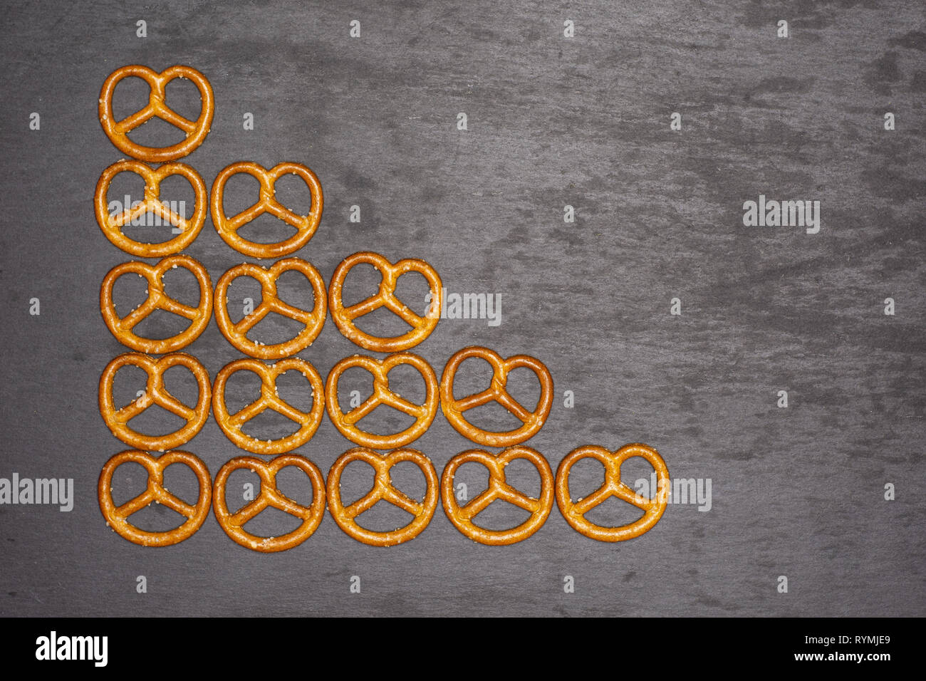 Lot of whole mini salted pretzels pyramid flatlay on grey stone Stock ...
