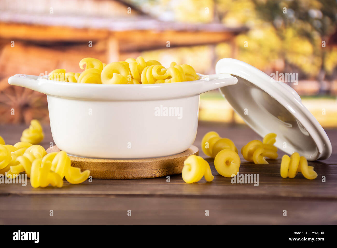 Lot of whole raw pasta funghetto variety in a ceramic stewpan in a yard ...