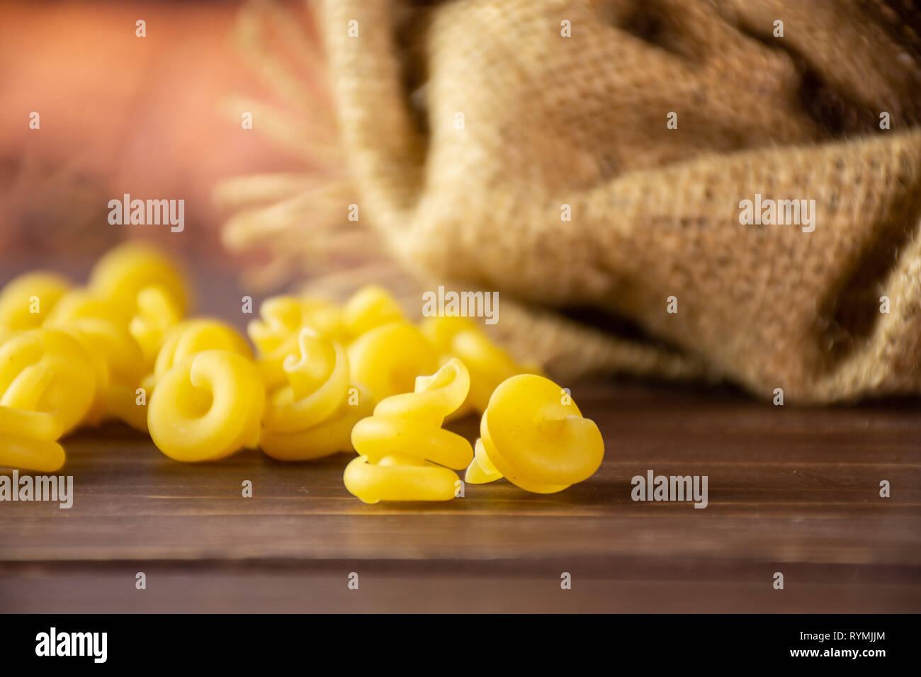 Lot of whole raw pasta funghetto variety with a jute bag in a yard ...