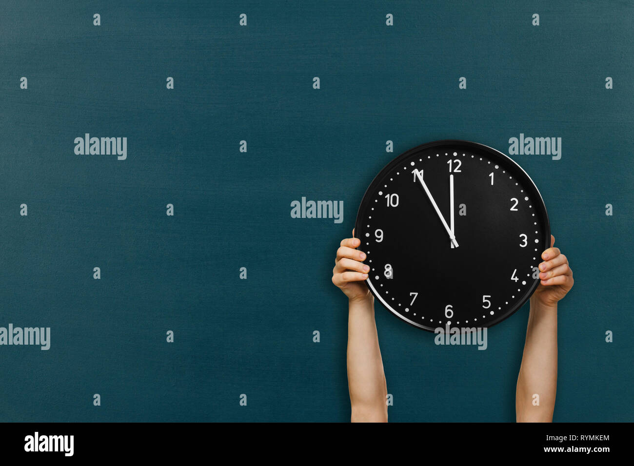 Man hold round wall clock on chalkboard background Stock Photo - Alamy