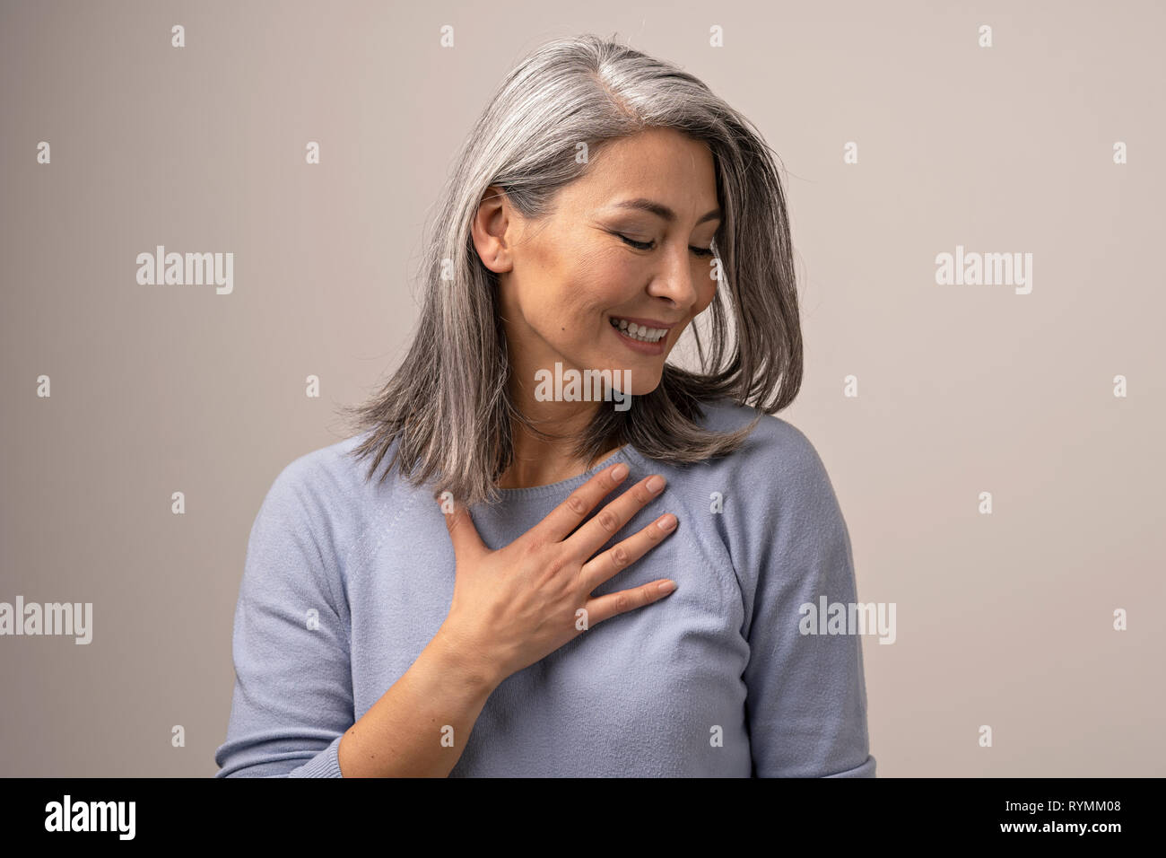 Charming Asian woman is touching her chest Stock Photo - Alamy