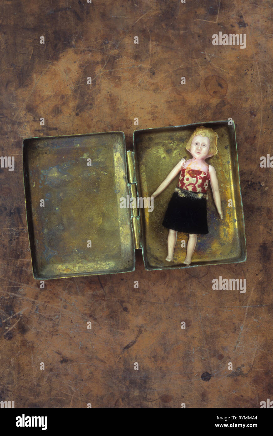 Miniature 1950s doll in skirt and top lying in tarnished brass box ...