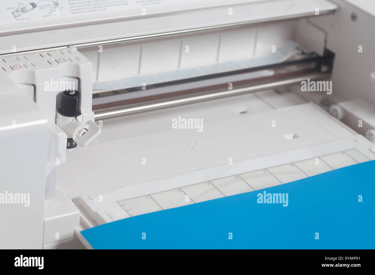 Cutting plotter with blue paper close up Stock Photo - Alamy