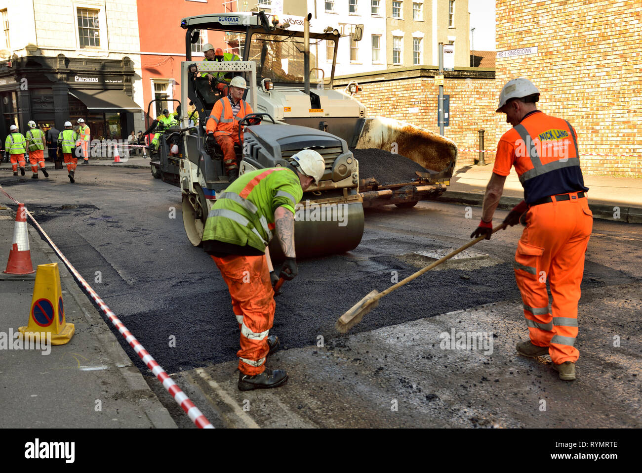 Road resurfacing manual spreading of tarmac and roller going over this ...