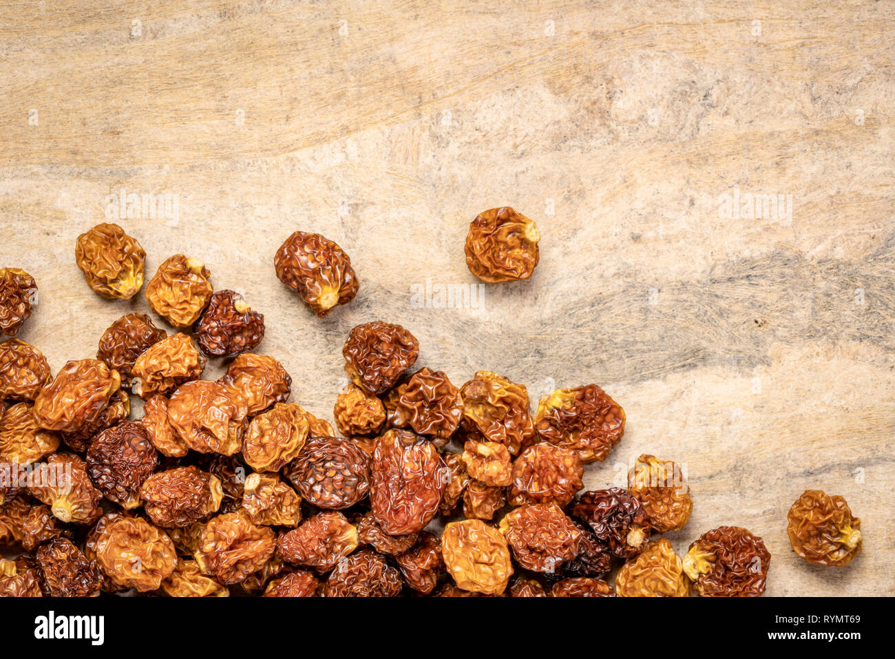 dried goldenberries on a textured bark paper background with a copy ...