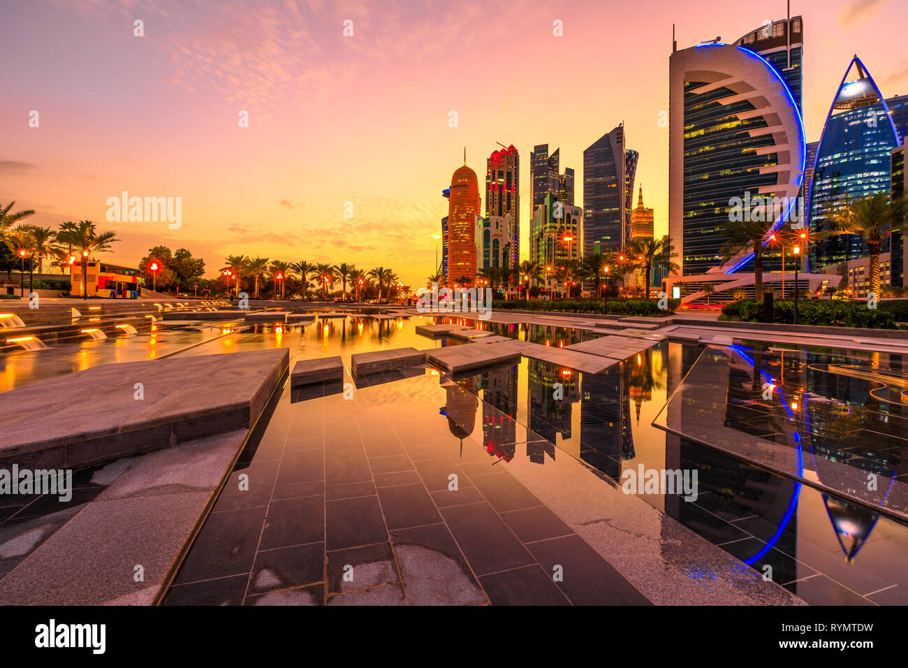 Doha West Bay high rises at sunset light reflecting in the water of ...