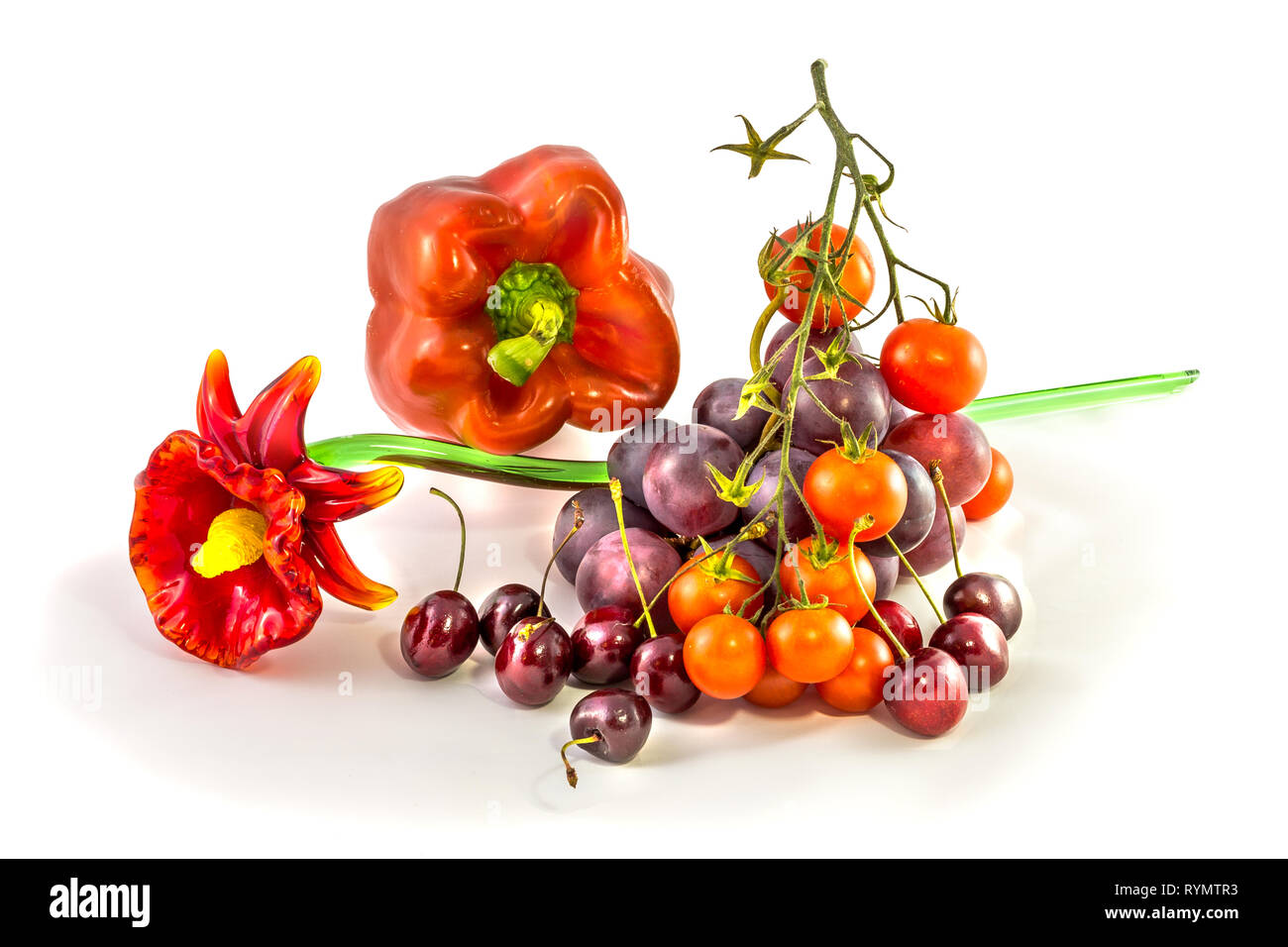 Group of assorted bright red fruit and vegetables with a glass flower ...