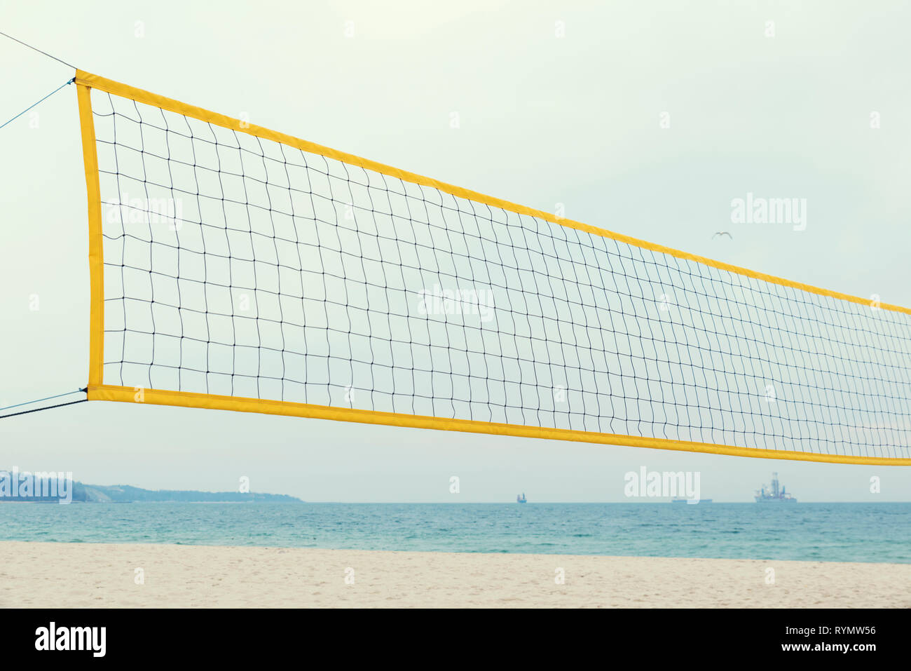 Yellow volleyball net on a sea shore Summer time No people Selective ...