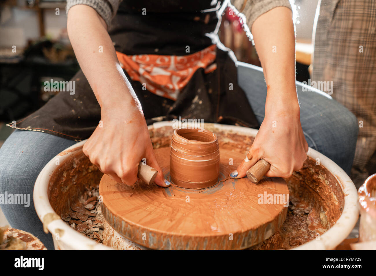Cuts of product with wire. Craftsman hands making pottery bowl. Woman ...