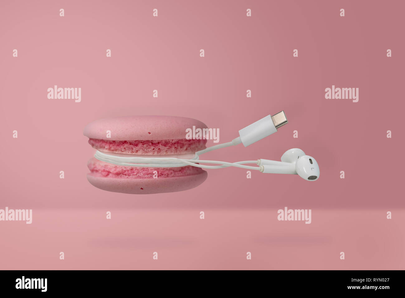 Contemporary art-macaroon and earphone on pink background with copy ...