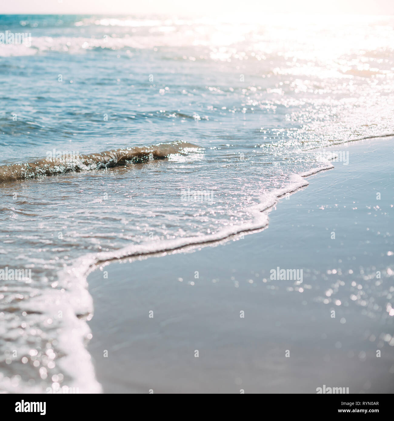Summer sand beach and seashore waves background. Defocused blurred ...