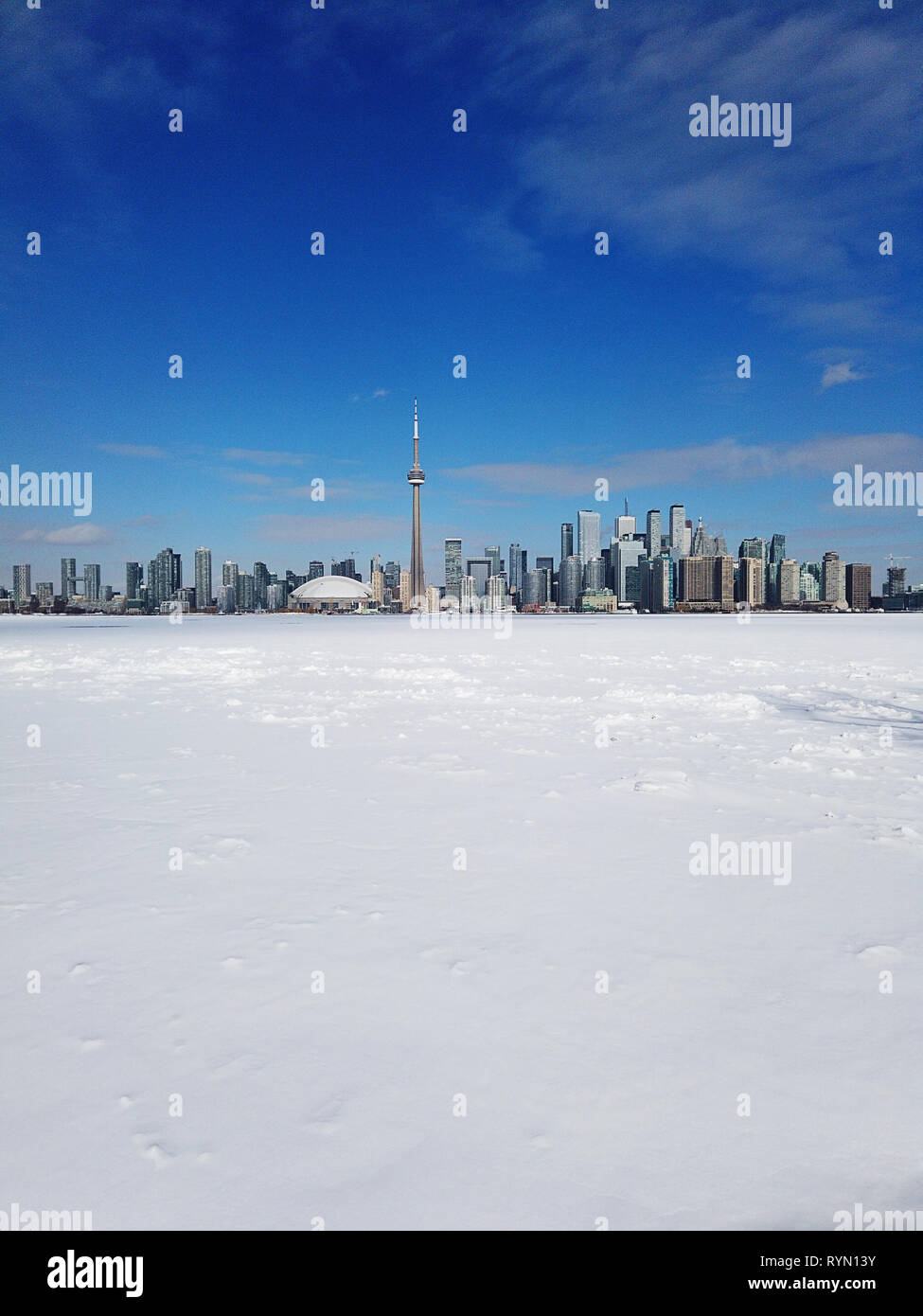 Toronto city skyline seen from toronto Islands over frozen lake Ontario ...