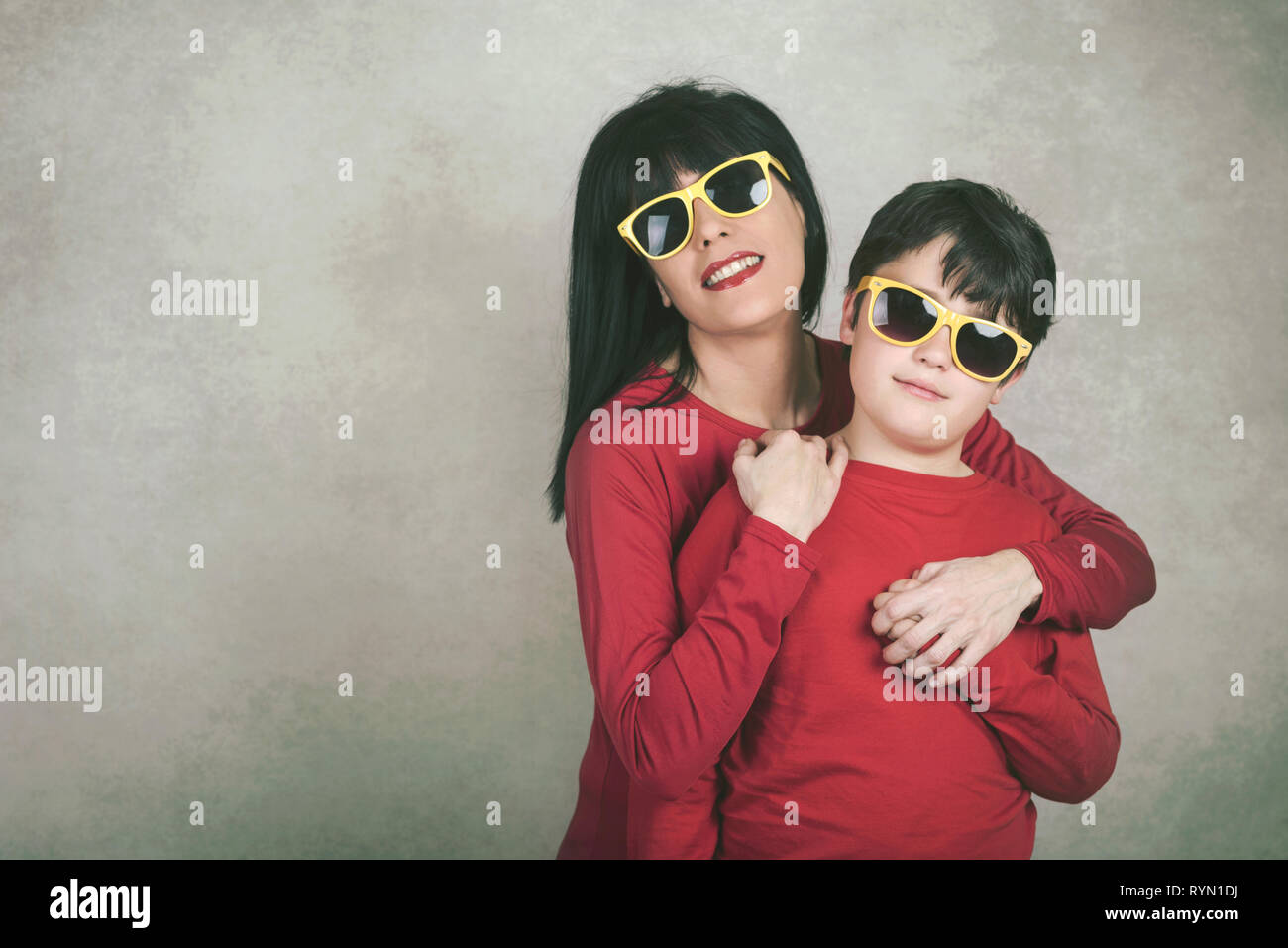 mother hugging her son against gray background Stock Photo - Alamy