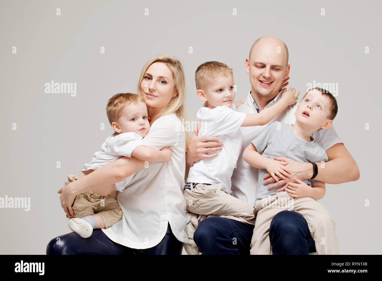Big and cheerful family, mom dad and three sons. Happy together. family portrait on light grey ...