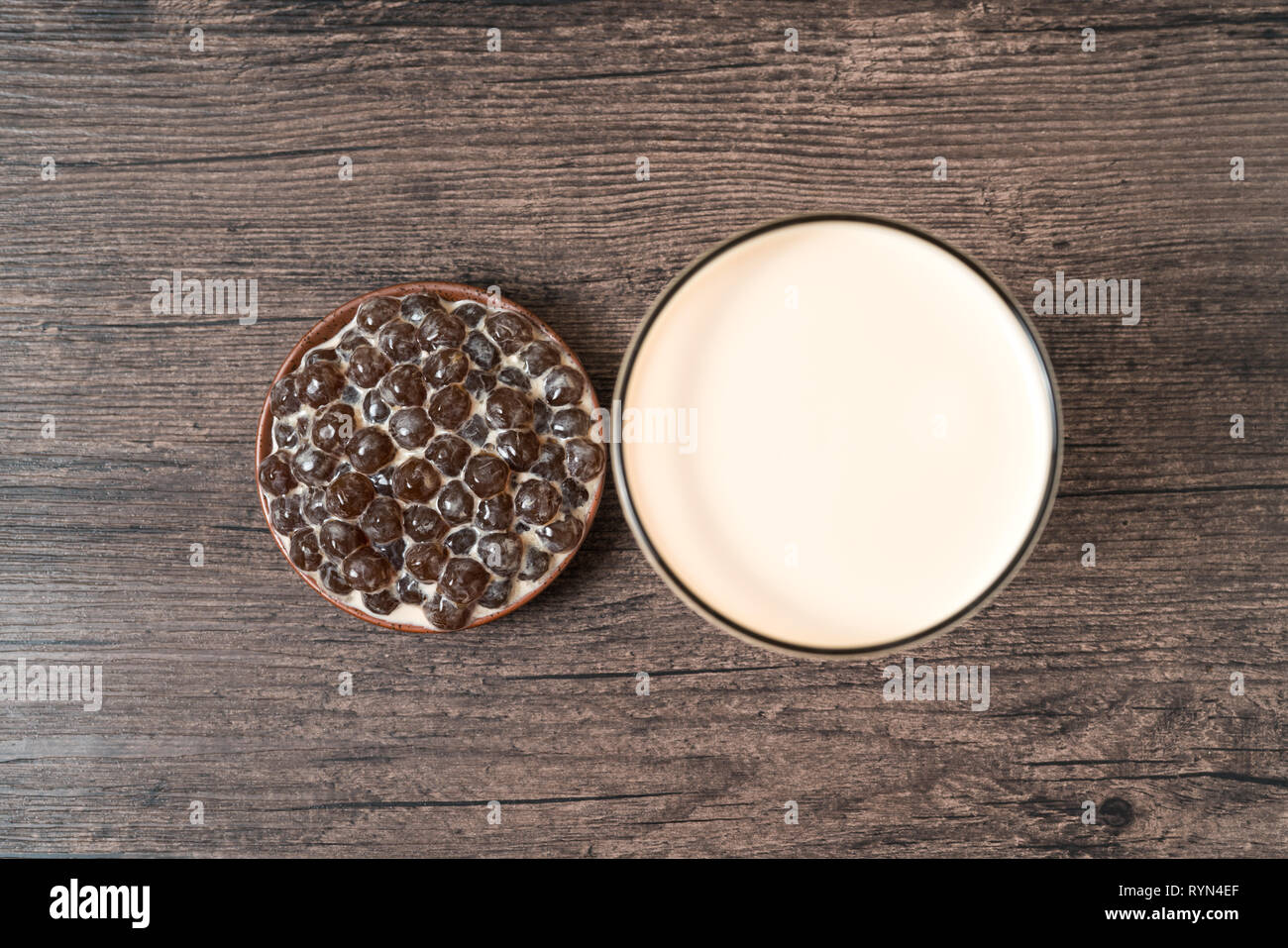 A glass cup of pearl milk tea (also called bubble tea) and a plate of ...