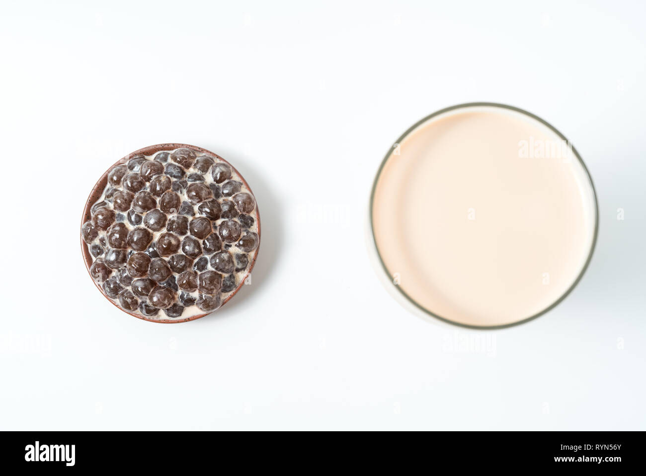 A glass cup of pearl milk tea (also called bubble tea) and a plate of ...