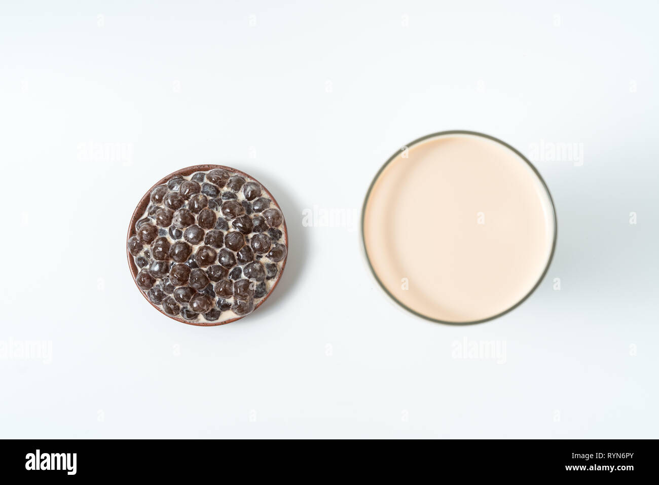 A glass cup of pearl milk tea (also called bubble tea) and a plate of ...