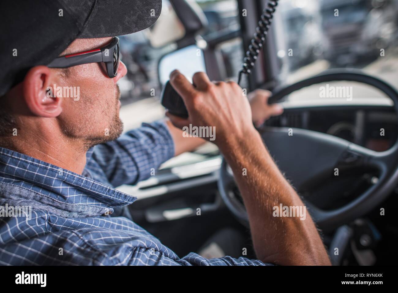 Caucasian Truck Driver in his 30s CB Talking with Other Drivers in the ...
