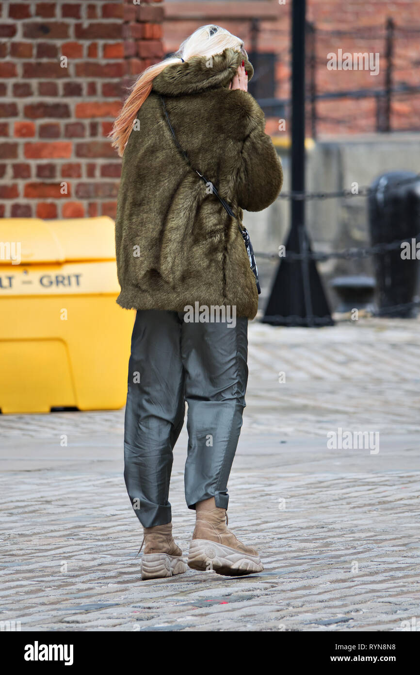 Woman walking in wind coat hi-res stock photography and images - Alamy