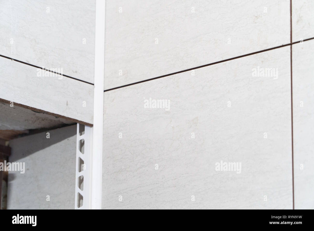 Сlose-up of seams between tiles. Finishing works. The technology of ... Сlose-up of seams between tiles. Finishing works. The technology of ...