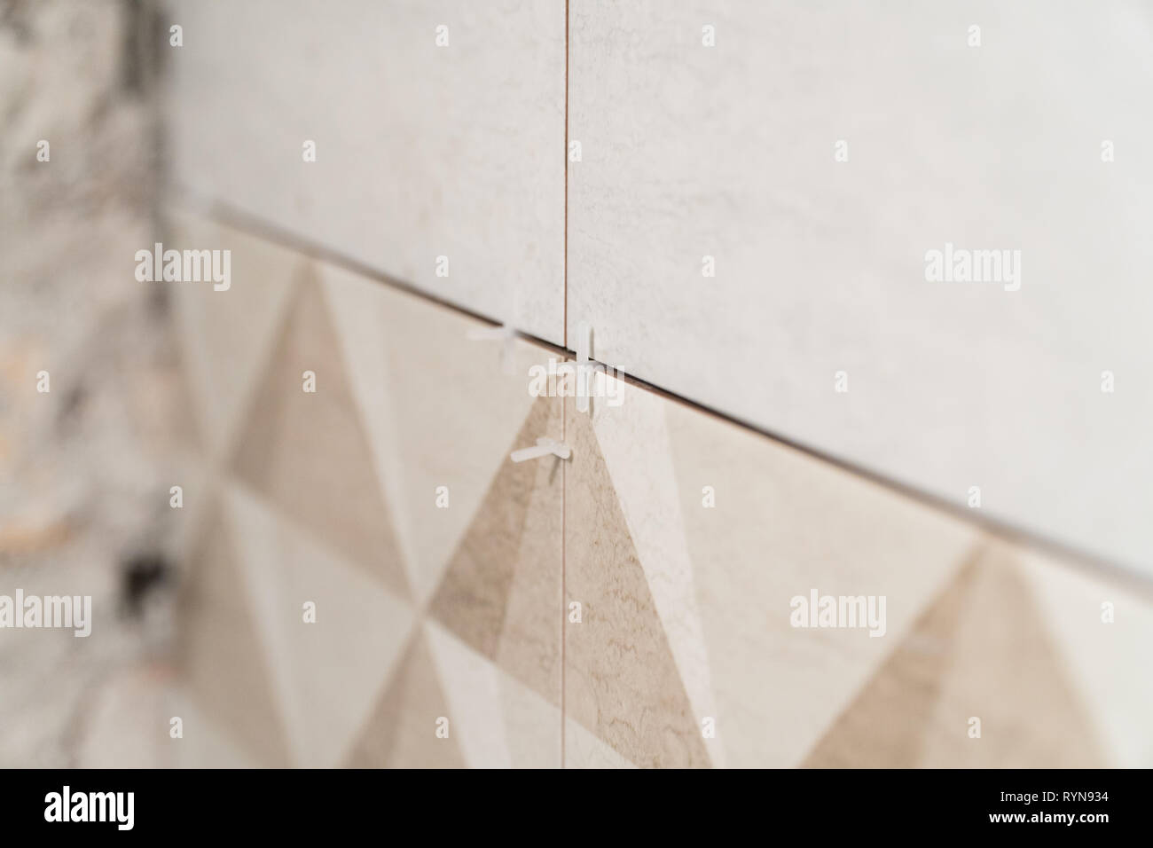 Сlose-up of seams with plastic crosses between tiles. Finishing works ... Сlose-up of seams with plastic crosses between tiles. Finishing works ...