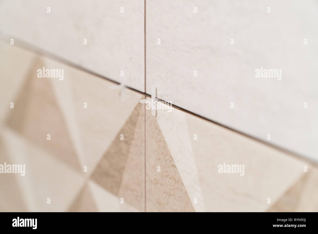 Сlose-up of seams with plastic crosses between tiles. Finishing works ... Сlose-up of seams with plastic crosses between tiles. Finishing works ...