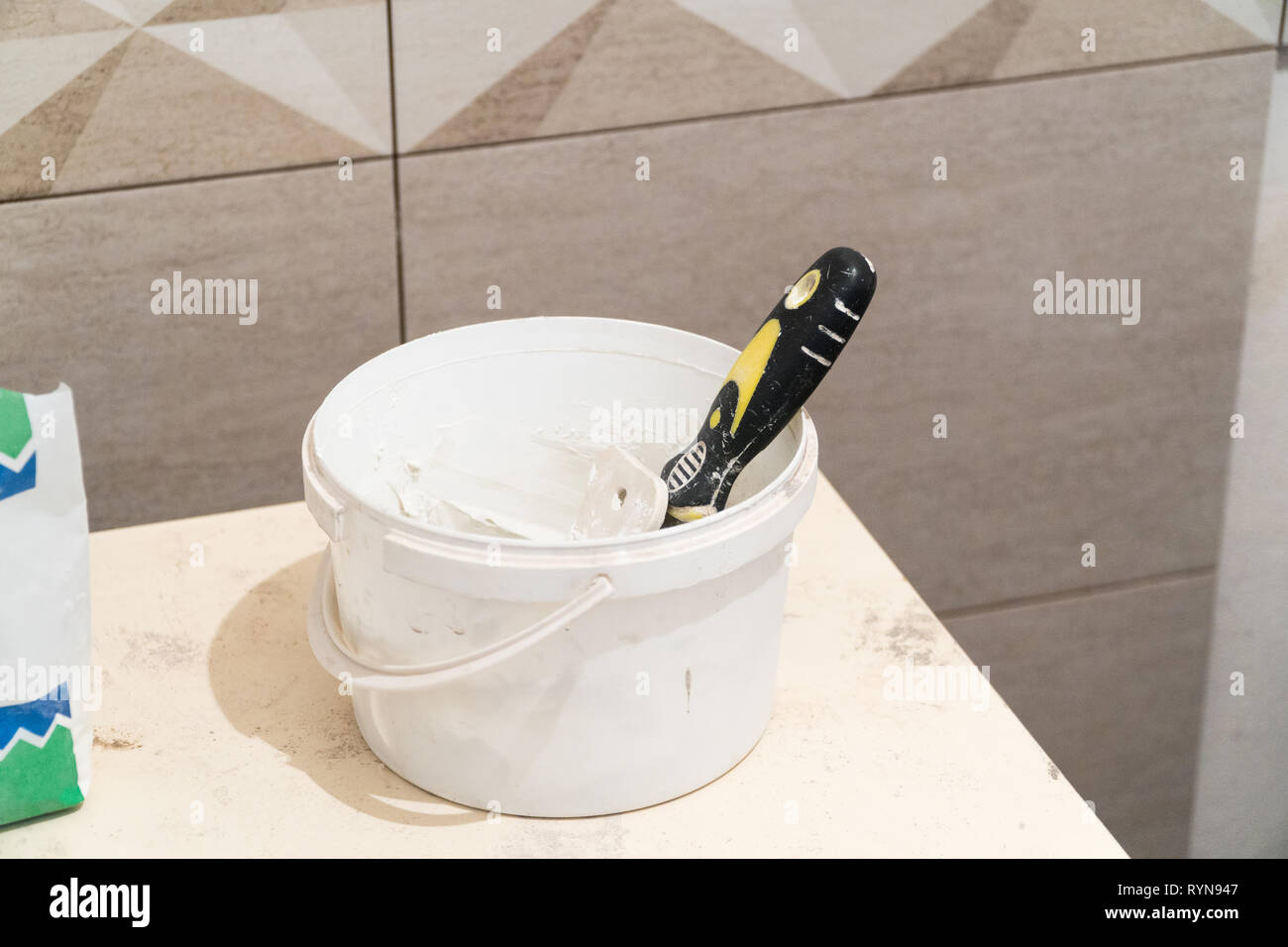 A bucket of putty for tile joints. Finishing works. The technology of ...