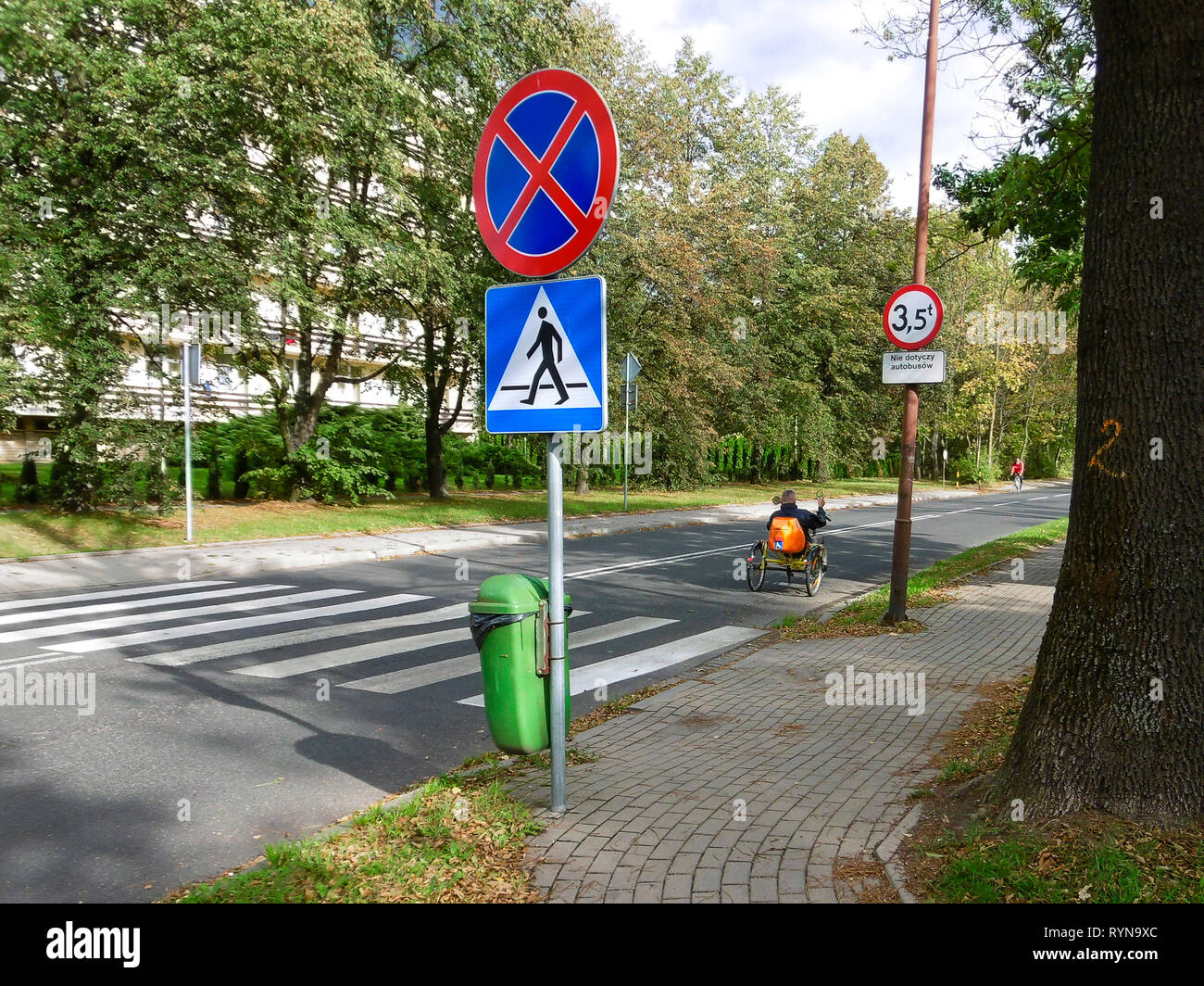 A disabled man is riding a disability bike - trike, on an empty road in ...