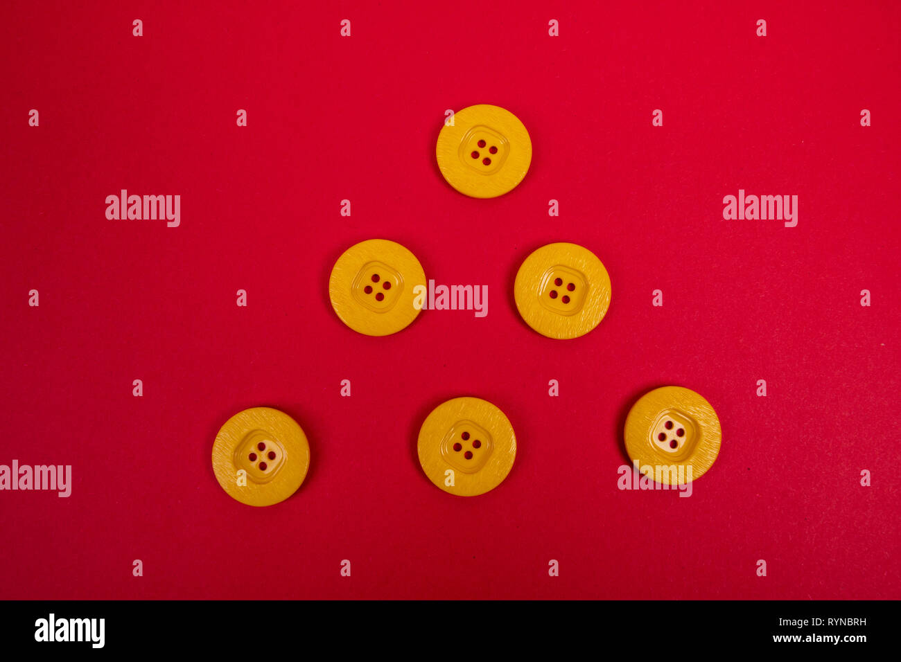 seven yellow buttons as a triangle on a red background Stock Photo - Alamy