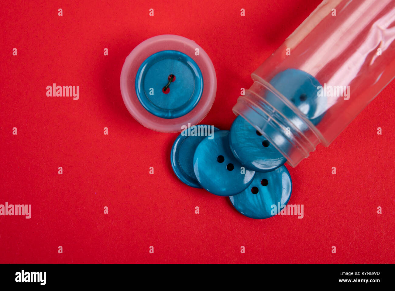 blue buttons from a button box on a red background Stock Photo - Alamy