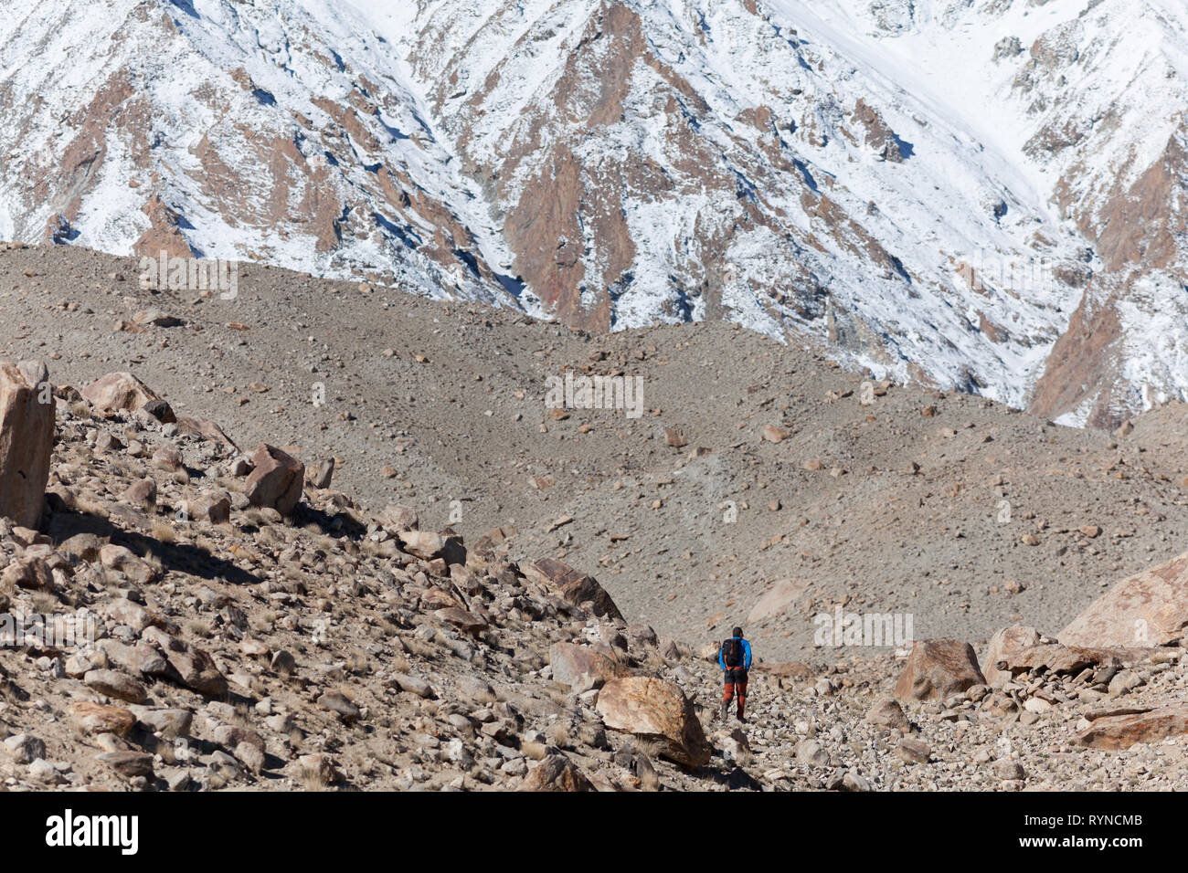 Lone male trekker hiking in the mountains in the area of Merak village ...