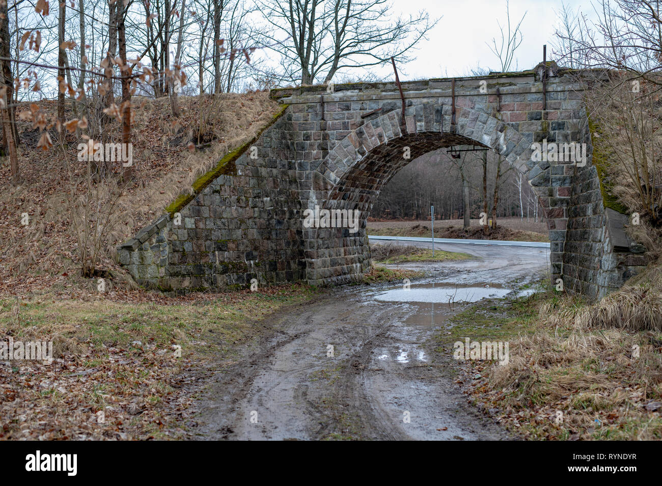 Stone viaduct over the old railway track. A dirt road leading under an ...