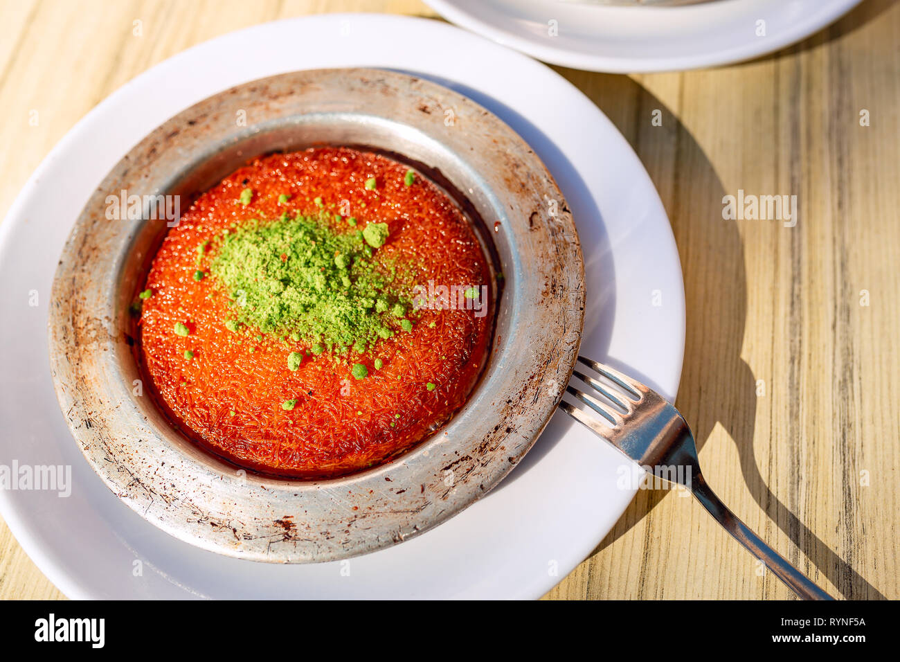 Turkish dessert kunefe, kunafa, kadayif with pistachio powder and ...