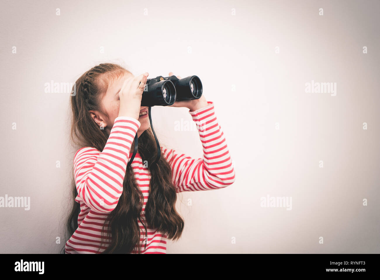 Little girl explorer is looking through binoculars Stock Photo - Alamy