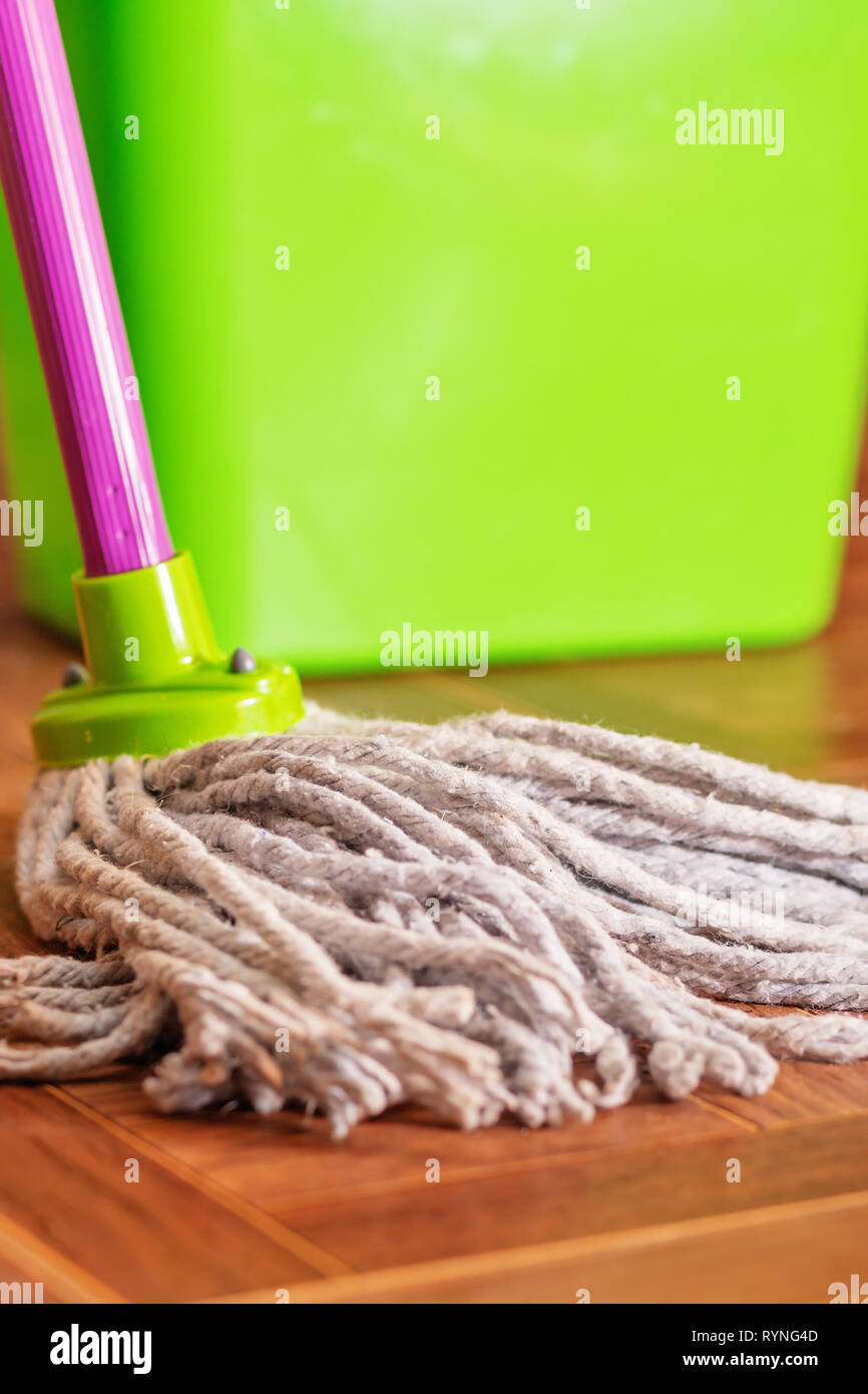 Rope mop for cleaning the floor on the background of a plastic bucket ...