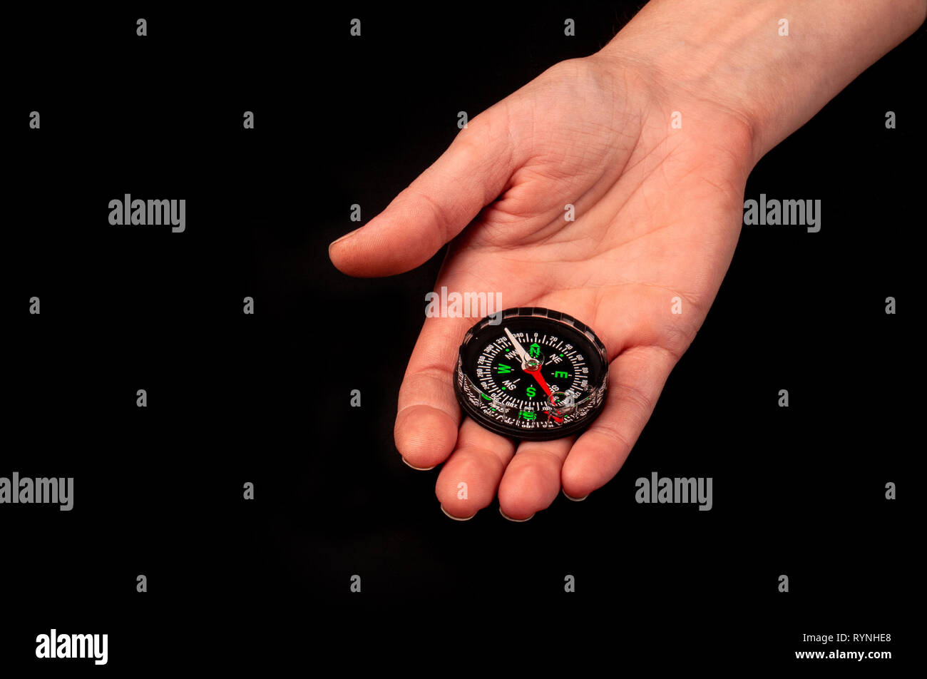 Hand holding the black compass isolated on black background Stock Photo ...