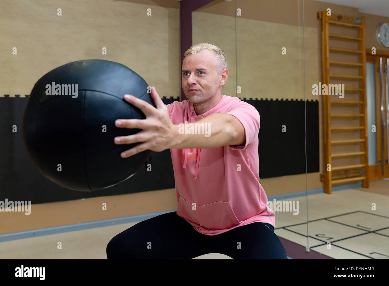 Man training in a gym. Fit young man in sportswear working out alone in ...