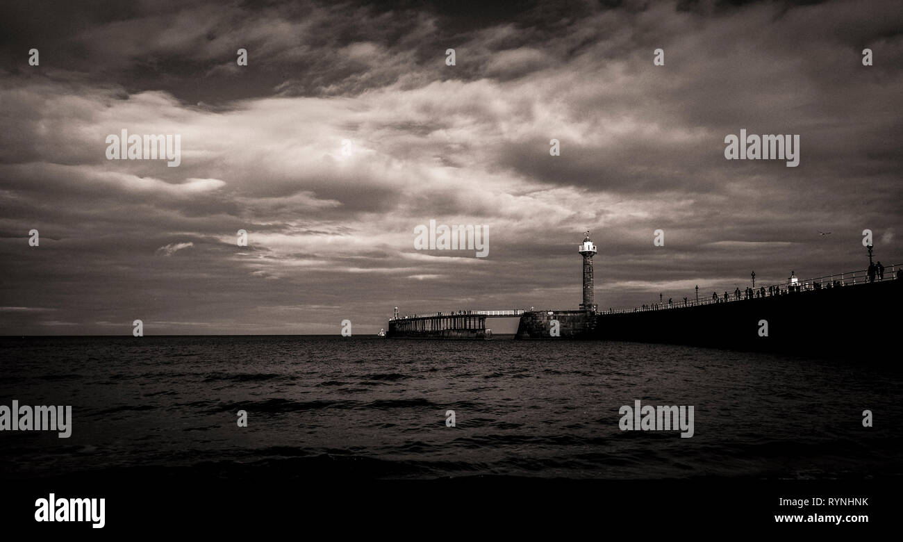 The harbour sea wall pier and old lighthouse, at Whitby, North ...
