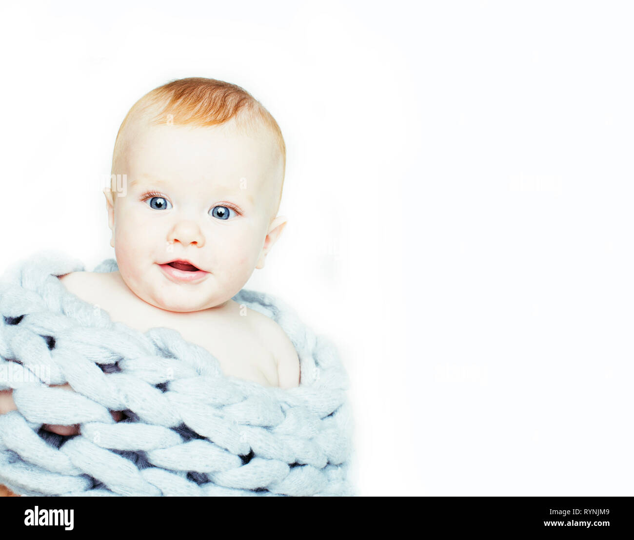 little cute red head baby in scarf all over him close up isolated ...