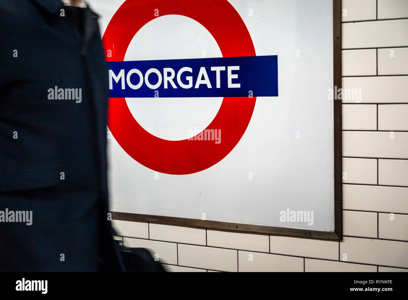 Commuter waking pass the Iconic circular London Tube sign on the ...