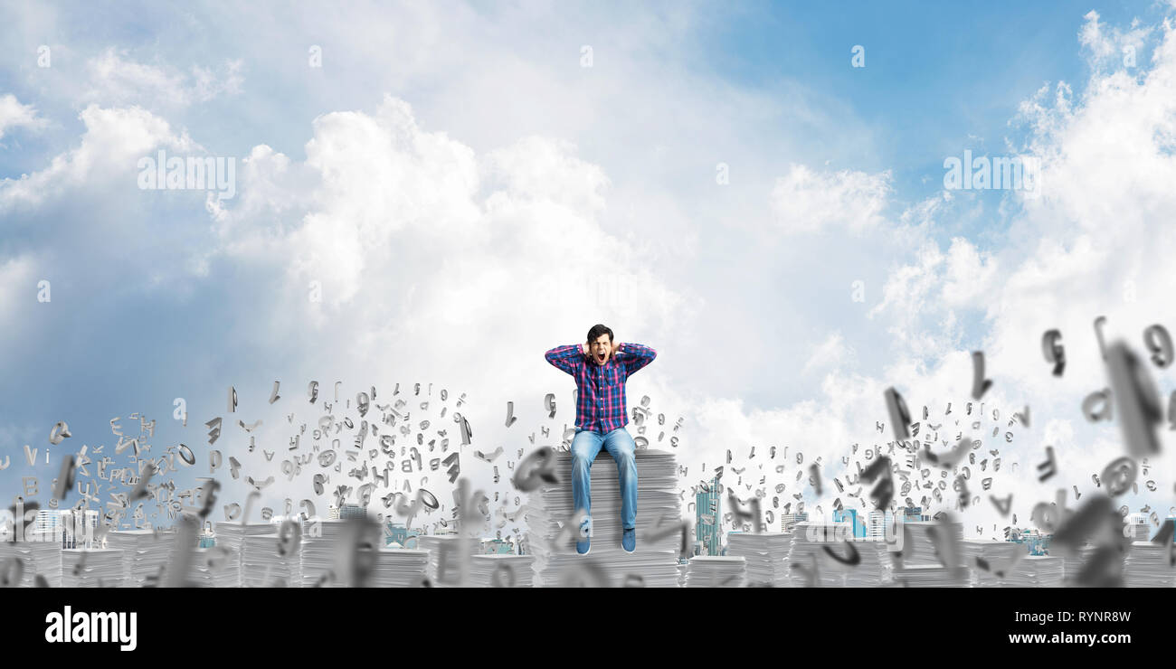Attractive man sitting on pile of paper documents Stock Photo - Alamy