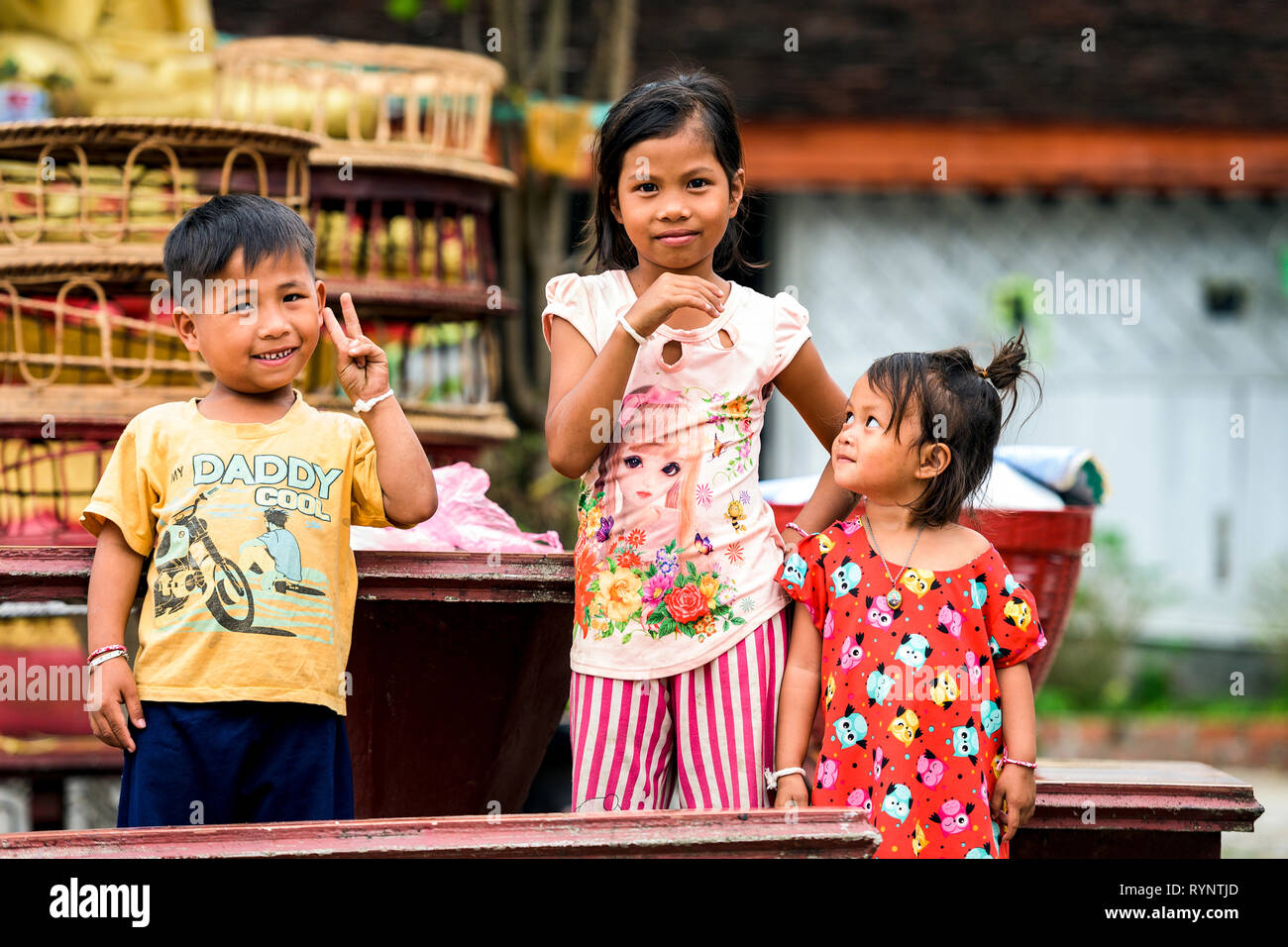 Portraits of three beautiful Laotian children who smile and have fun in ...
