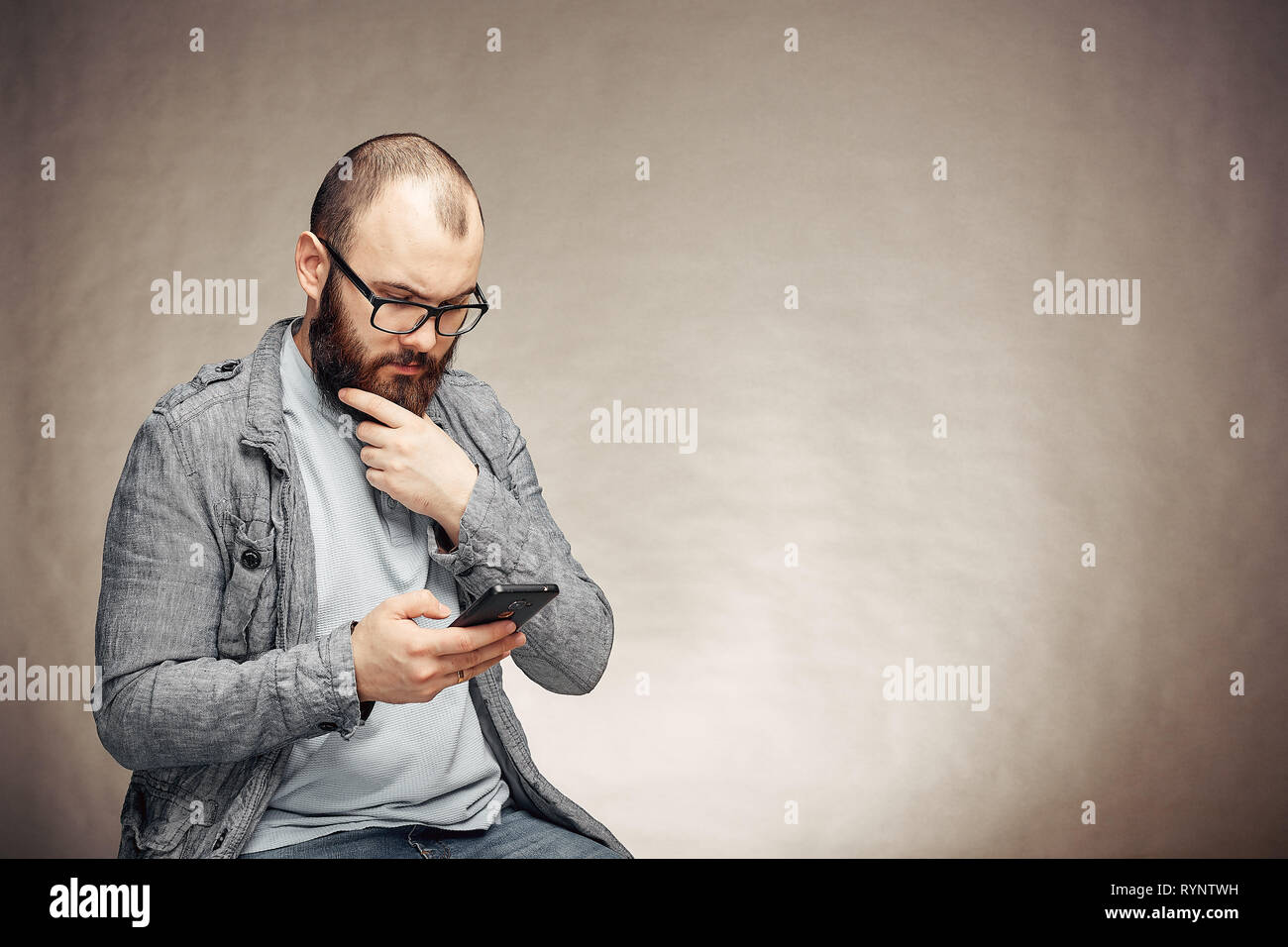 lifestyle brooding man with a beard and a telephone, background ...