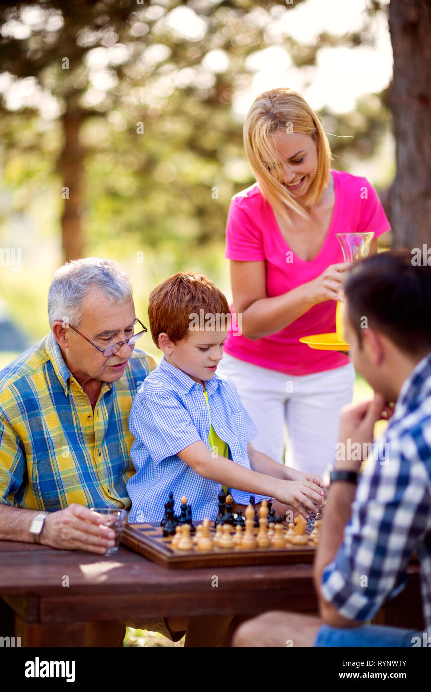 family relax together in nature and playing chess Stock Photo - Alamy