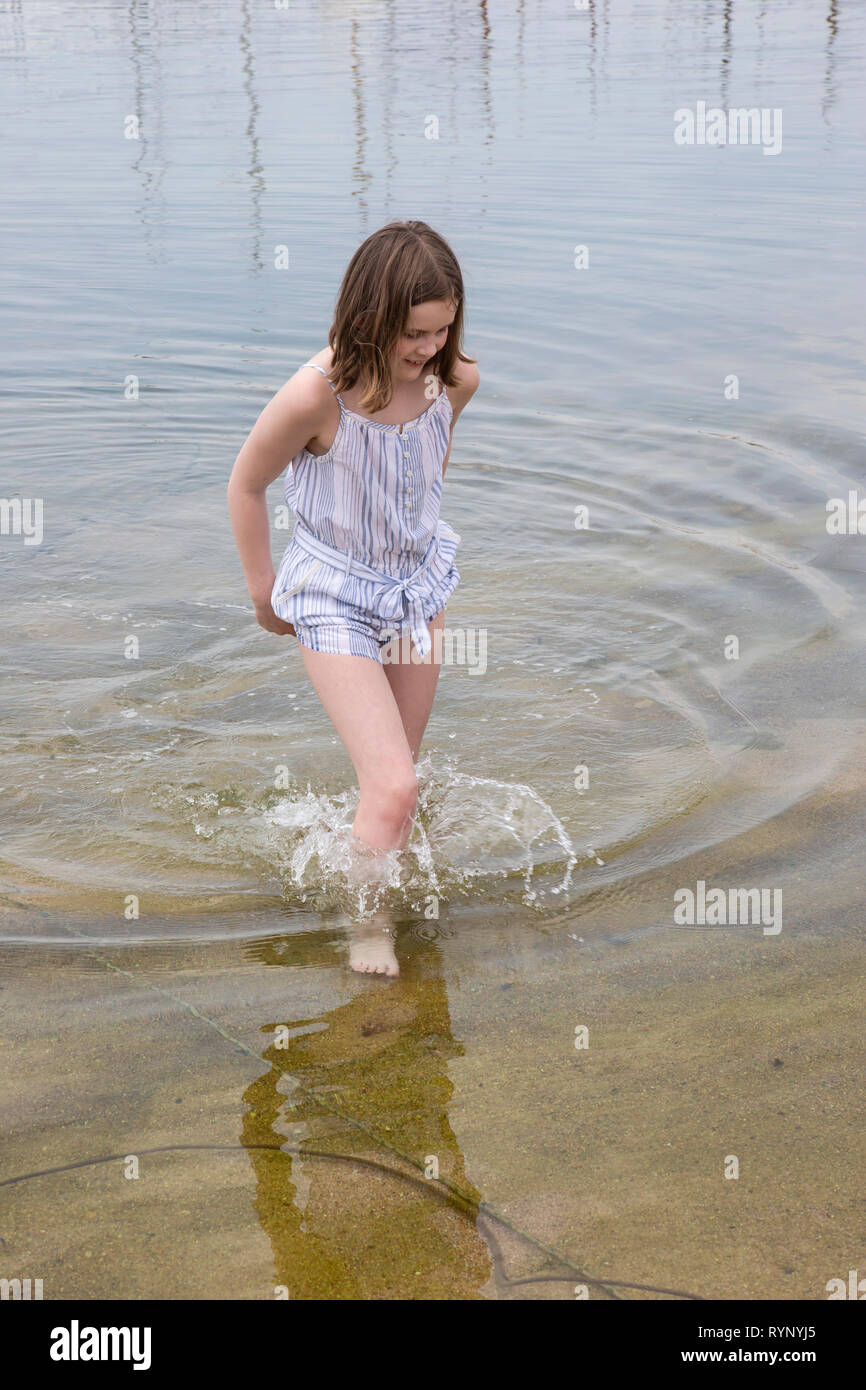 Young girl paddling in the sea in Palamos in Spain Stock Photo - Alamy
