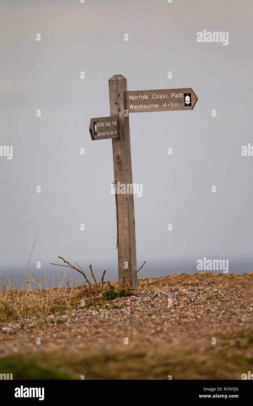 Wooden signpost on a Norfolk beach indicating the Norfolk coastal path ...