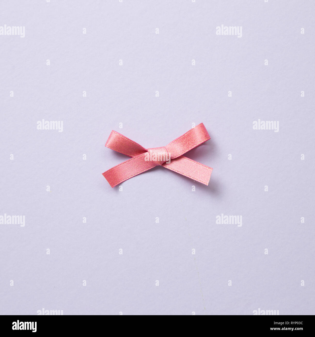 Decorative pink bow ribbon on purple background Stock Photo - Alamy
